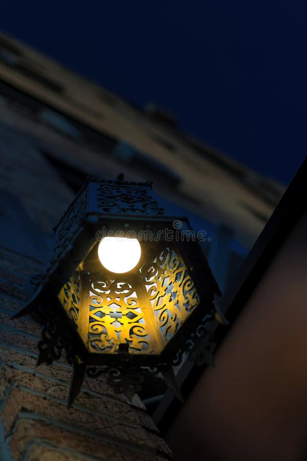 A Single Lantern and Glowing Lightbulb, Mounted on a Building Wall at ...