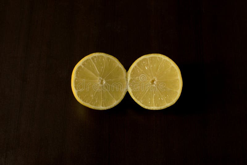 Single Lemon Sliced in Half - on Dark Background Stock Photo - Image of ...