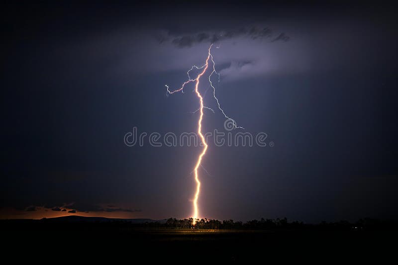 A Single Lightning Bolt Striking the Ground, Illuminating Dark Sky with ...