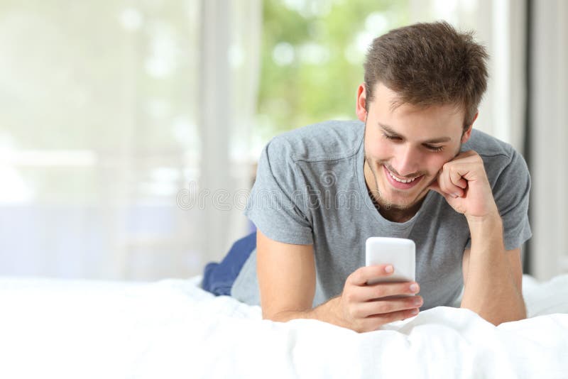 Single Man Checking Phone on a Bed Stock Image - Image of lifestyle ...