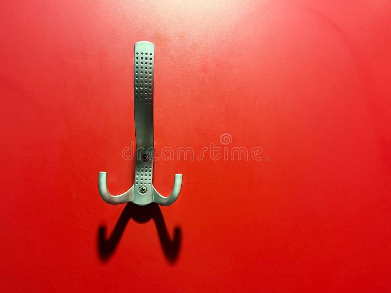 Single Metal Hook Casting Shadow on Bright Red Wall Surface Stock ...