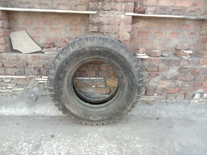 Single-old-rubber-tire-and-wall-background. Stock Photo - Image of ...