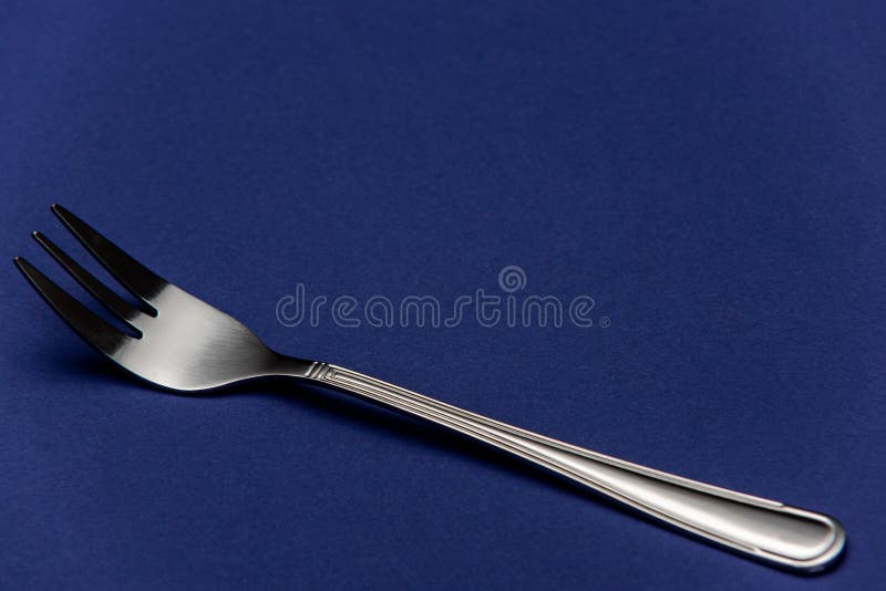 Single One Stainless Steel Fork on Blue Background. Detail Close Up ...