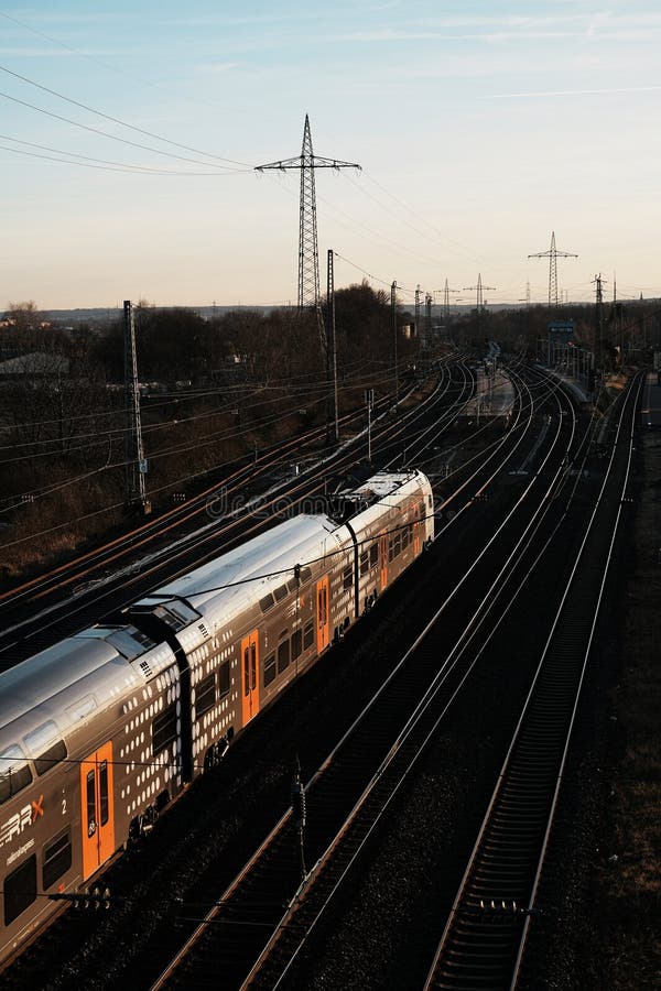 Single Passenger Train on Rail Tracks, with Electrical Wiring Supplying ...