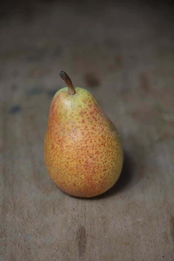 Single Red and Green Pear on a Wooden Table Stock Image - Image of ...