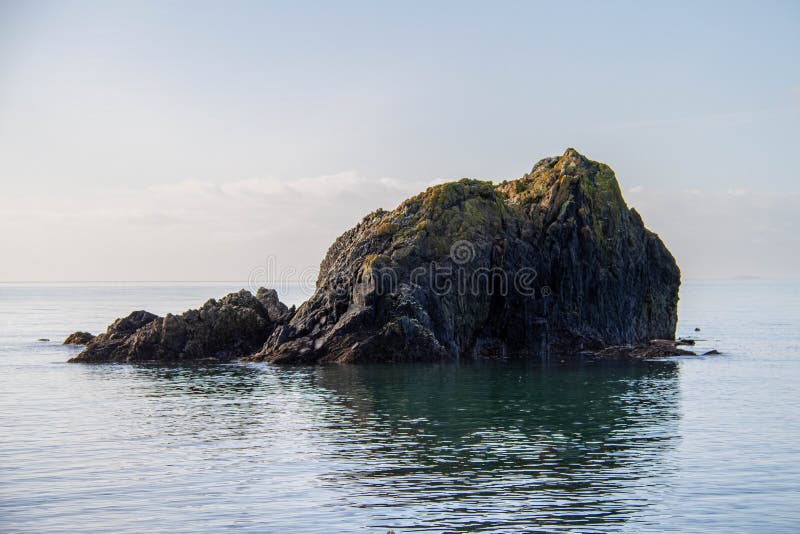 A Single Rock Protruding from the Surrounding Blue Ocean Stock Image ...