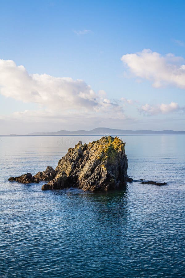 A Single Rock Protruding from the Surrounding Blue Ocean Stock Photo ...
