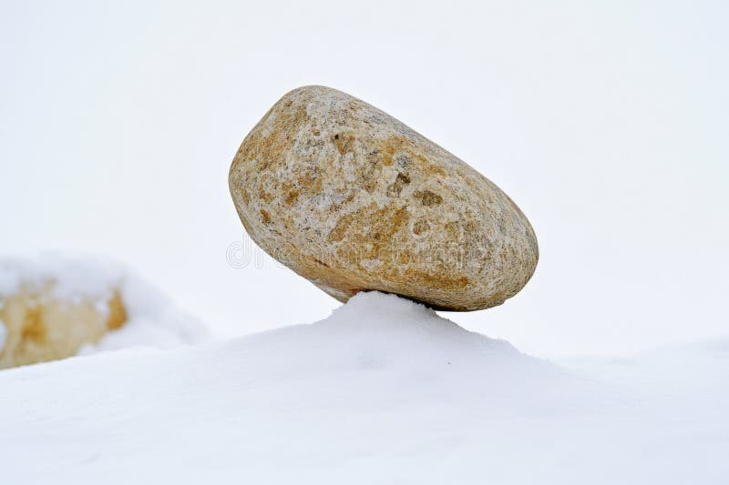 A Single Rock Sits Atop a Pile of Snow Stock Image - Image of cold ...