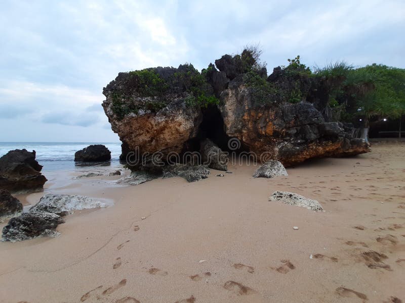Single Rocks on a Sand Beach Against Blue Ocean and Cloud Sky at ...