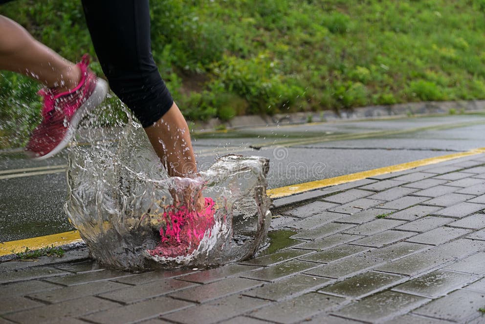 Single Runner Running in Rain and Making Splash in Puddle Stock Image ...