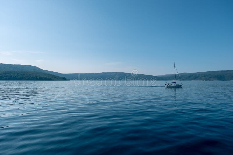 Single Ship on the Middle of the Sea Surrounded by High Rocky Mountains ...