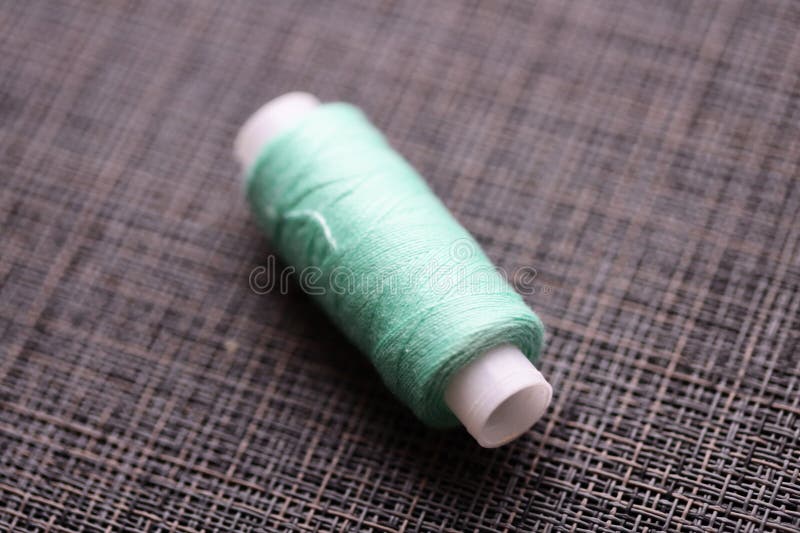 A Single Spool of Thread Sitting on a Table, Possibly for Sewing or ...