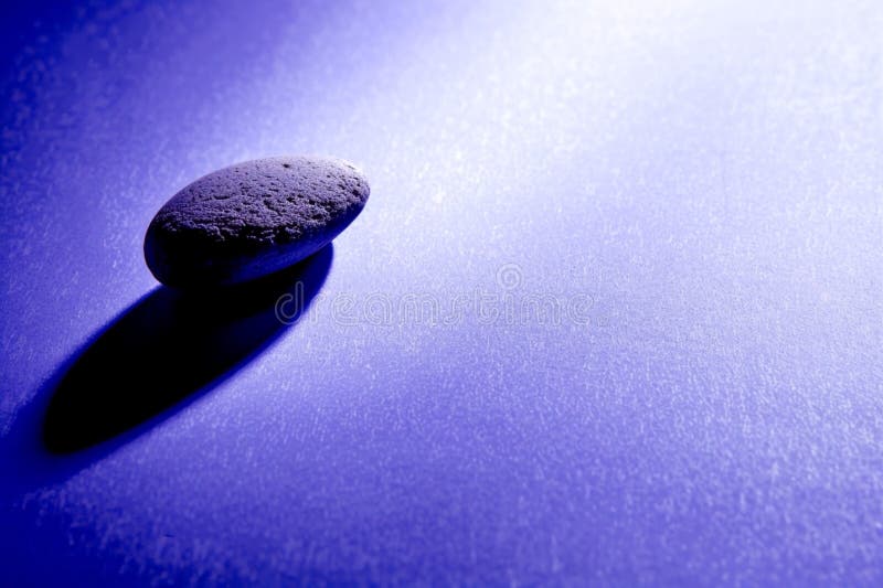 Single Stone Casting a Shadow on a Blue Textured Surface Stock Photo ...