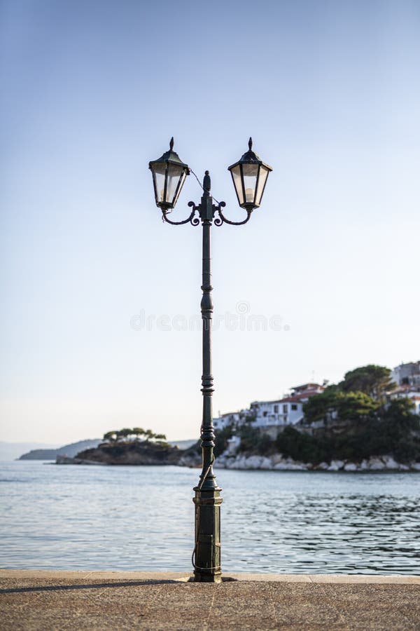 Single Street Lamp on the Pier Seafront with Flowing Water at Sunset ...