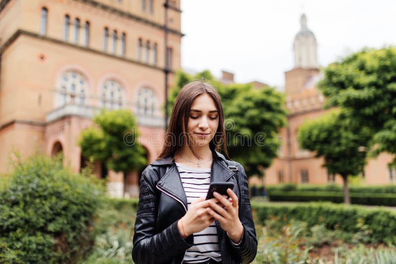 Single Student Walking and Reading Mobile Phone Messages with a ...