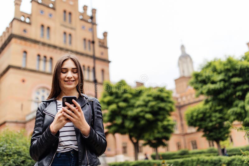 Single Student Walking and Reading Mobile Phone Messages with a ...