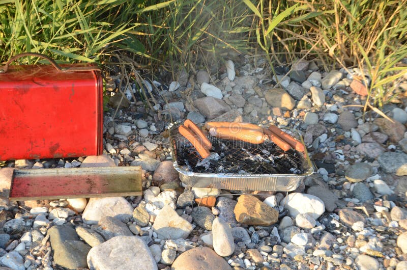 Single Use BBQ with Sausages on a Stony Shore Stock Photo - Image of ...