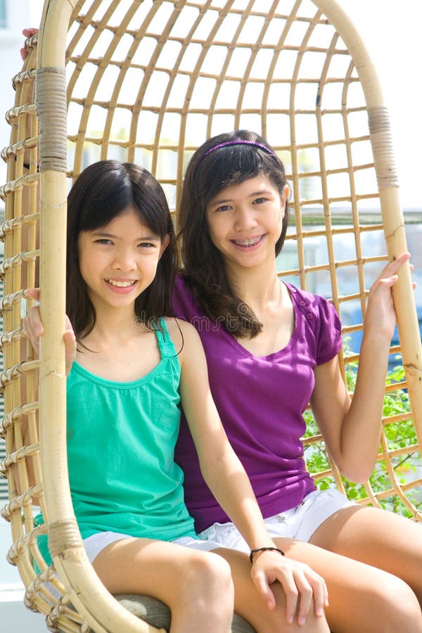 Sisters Enjoying the Rattan Swing Stock Photo - Image of enjoy, fashion ...