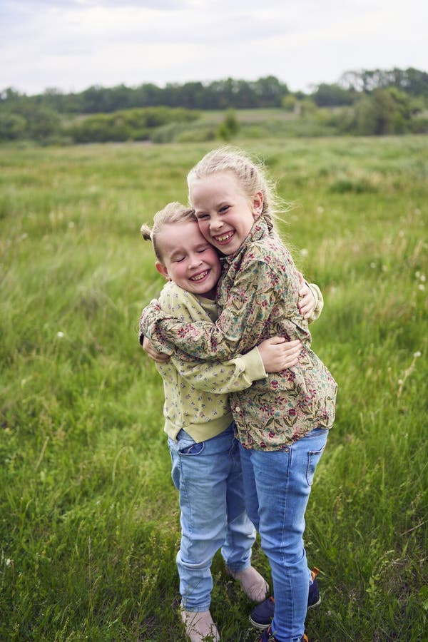 Sisters Hug and Protect Each Other from the Wind in the Field Stock ...