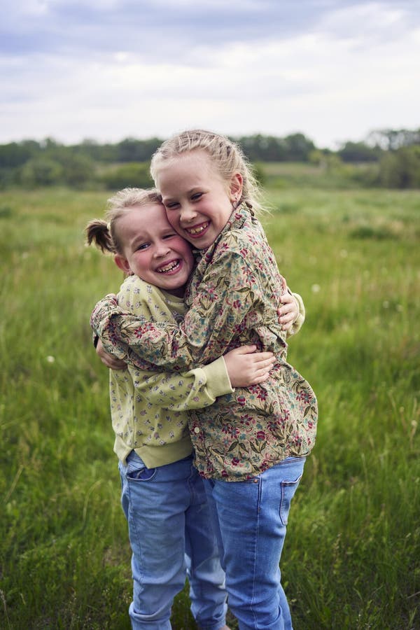 Sisters Hug and Protect Each Other from the Wind in the Field Stock ...