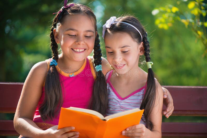 Two girls reading a book stock photo. Image of cute, busy - 26674958