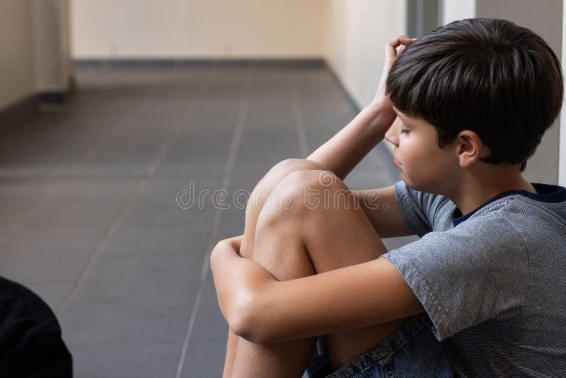 Sitting Alone in School Hallway, Boy Looking Down and Thinking Deeply Stock Photo - Image of ...