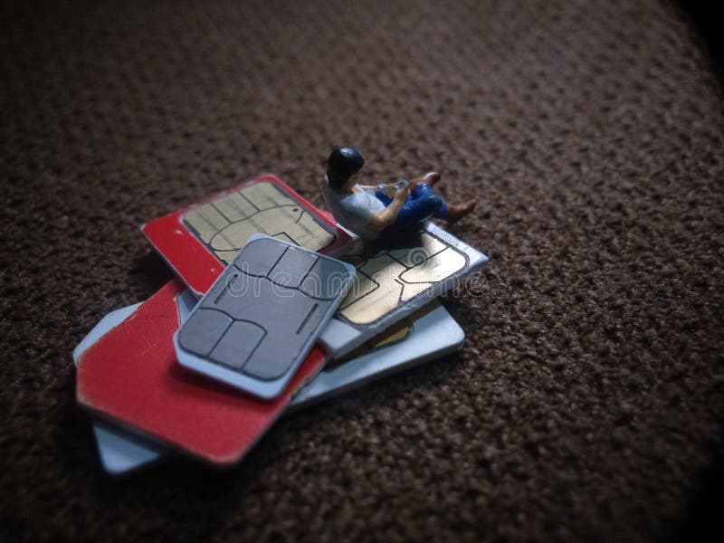 Sitting Mini Figure Man Toy Holding Smartphone at SIM Card ...