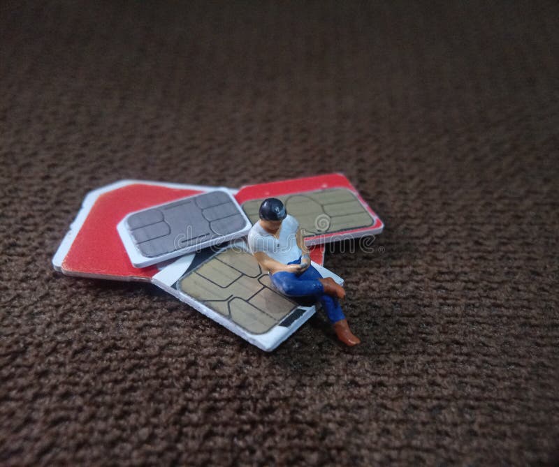 Sitting Mini Figure Man Toy Holding Smartphone at SIM Card ...
