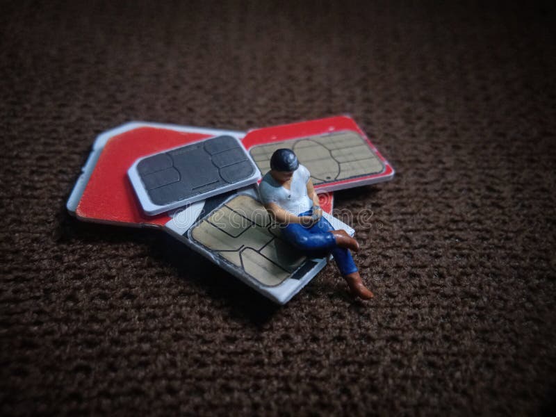 Sitting Mini Figure Man Toy Holding Smartphone at SIM Card ...
