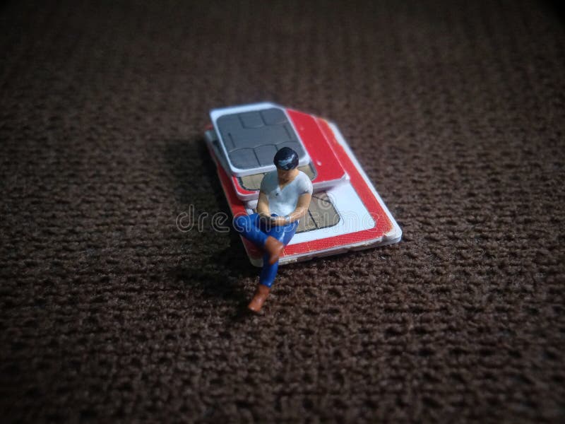 Sitting Mini Figure Man Toy Holding Smartphone at SIM Card ...