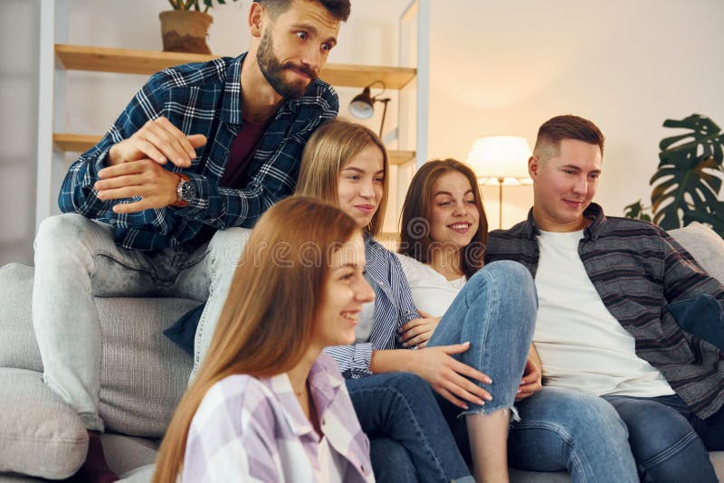 Sitting on the Sofa. Group of Friends Have Party Indoors Together Stock ...