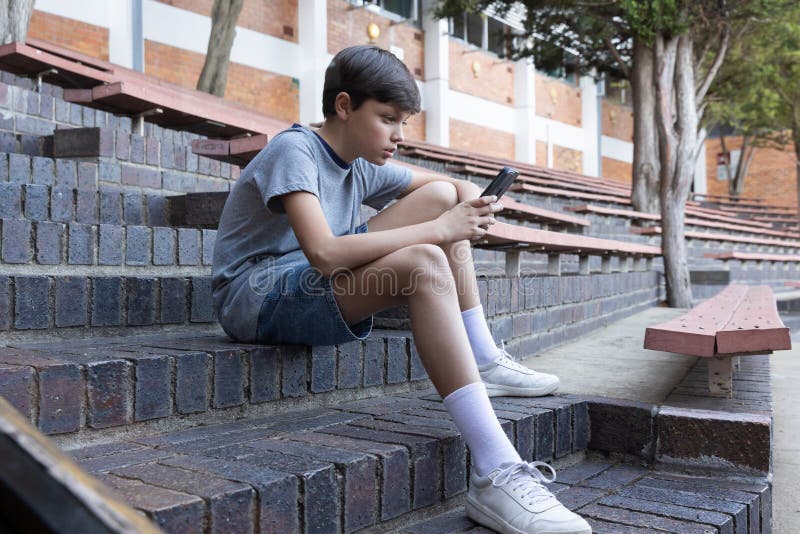 Sitting on Steps, Boy Using Smartphone at School, Concentrating on ...
