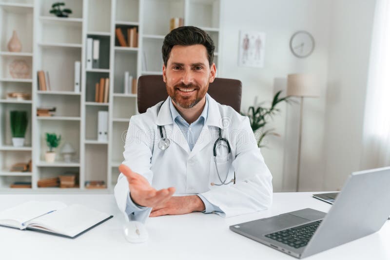 Sitting by a Table. Doctor in Formal Clothes is Working in the Cabinet ...