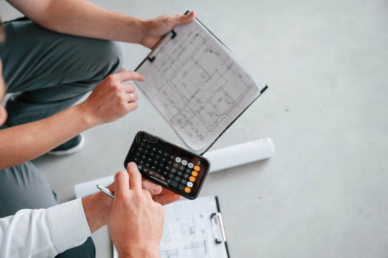 Sitting, Using Calculator. Manager with Foreman are Working on the ...