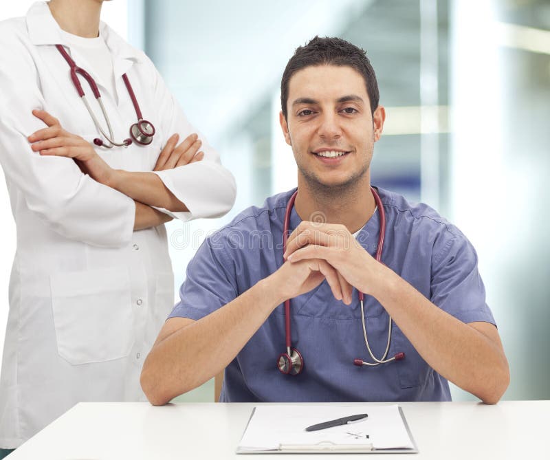 Sitting Young Doctor Man and His Nurse Stock Photo - Image of table ...