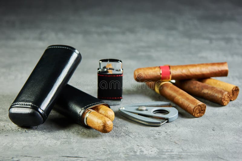 Six Cuban Cigars on a Stone Table with a Lighter, Cutter and a Leather ...