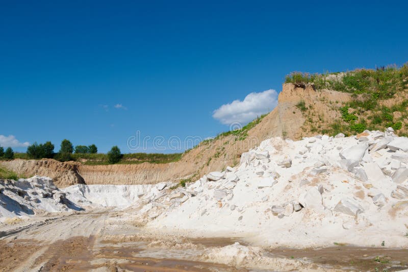 A Sizable and Large Pile of Various Rocks is Resting Atop a Dirt Hill ...