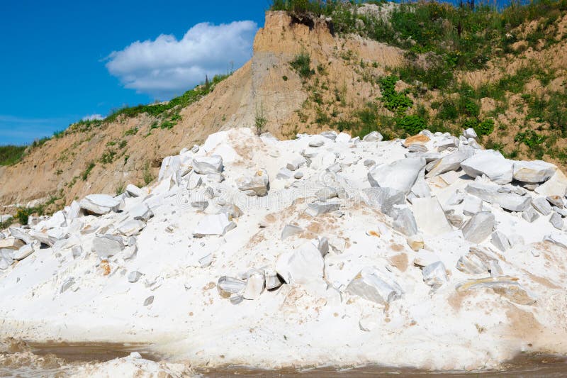 A Sizable and Large Pile of Various Rocks is Resting Atop a Dirt Hill ...
