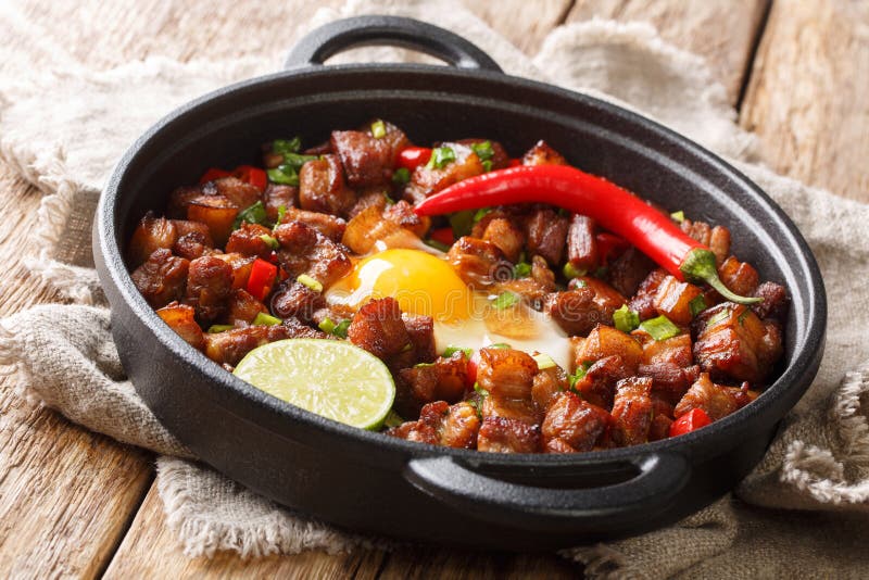 Sizzling Spicy Pork Sisig with Egg Ang Lime Close-up in a Pan ...