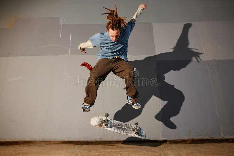 Skateboarder Performing Mid-Air Trick with Shadow Cast Stock Photo ...