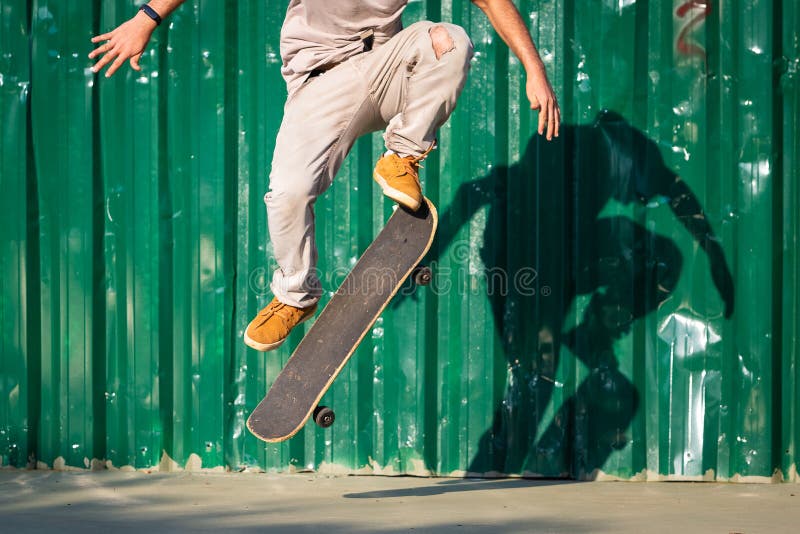 Skateboarder Practicing Tricks with the Shadow Projected on the Wall ...
