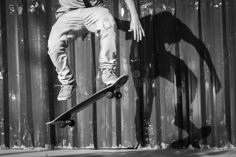 Skateboarder Practicing Tricks with the Shadow Projected on the Wall ...