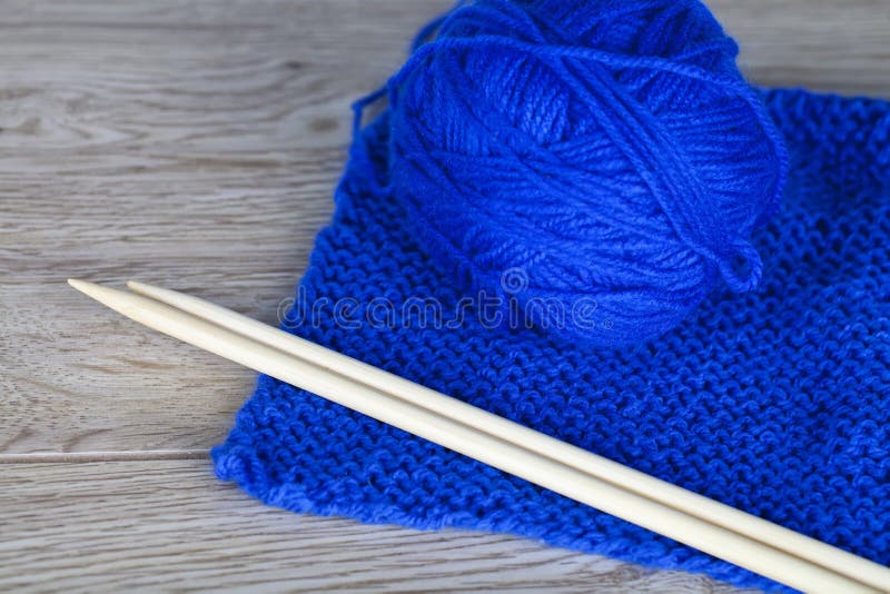 Skein of Blue Yarn with Completed Knitting and Bamboo Needles Stock ...