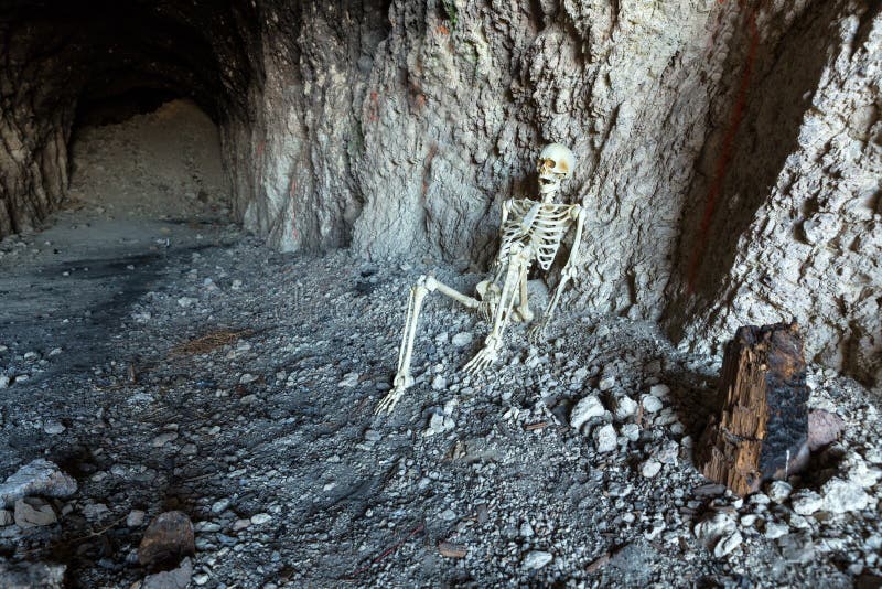 Skeleton in a Dark Cave in the Ground Lying on Rocks Stock Image ...