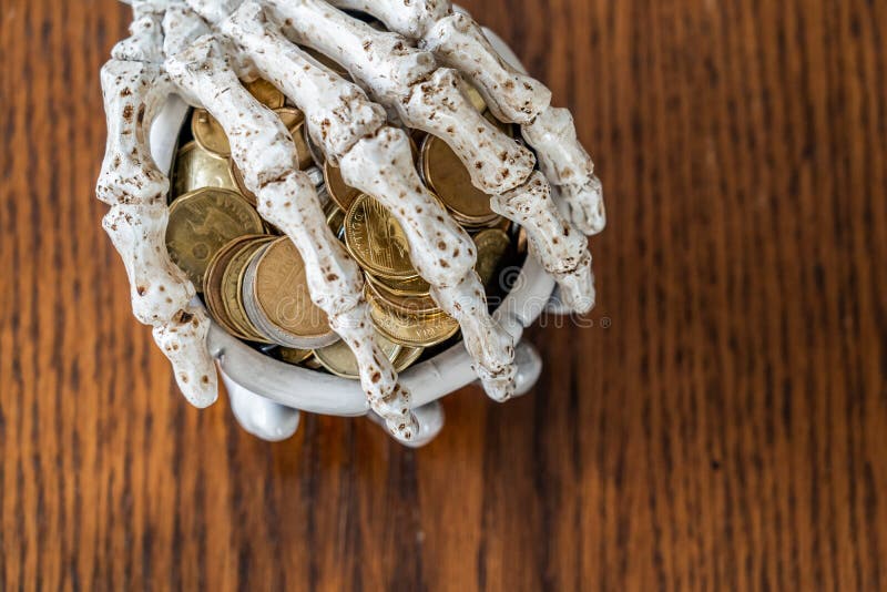 2 Skeleton Hands Holding Bowl of Coins for Halloween Stock Photo ...
