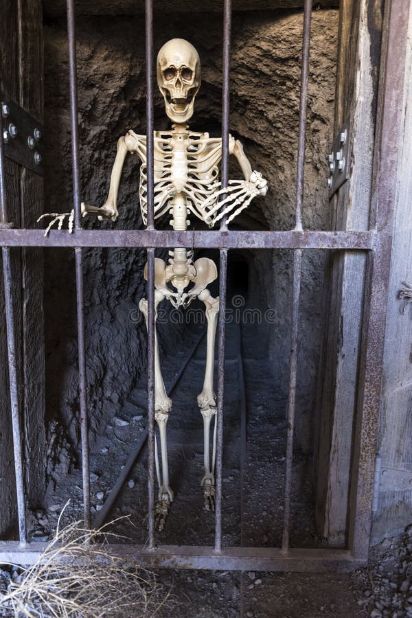 Skeleton Hanging on To the Bars of a Metal Gate Trapped Inside a Mine ...