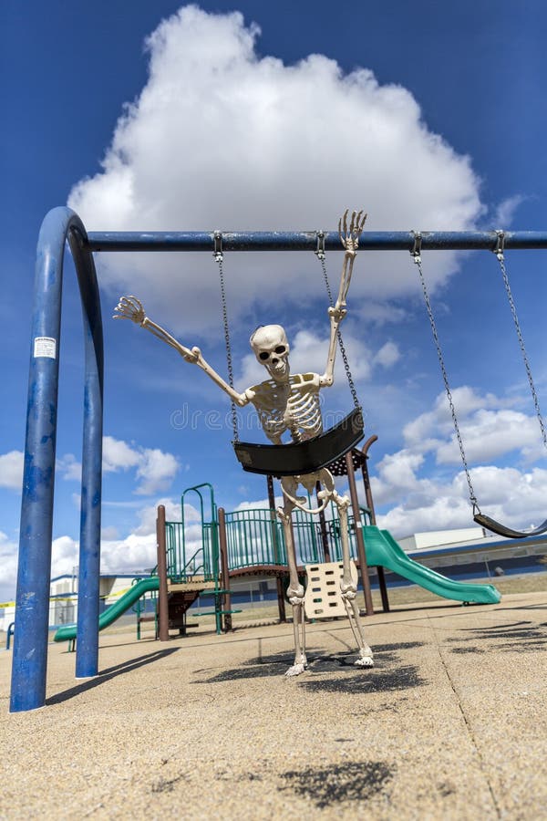 Skeleton Playing Superman On A Child's Swing In An Empty Park Stock ...