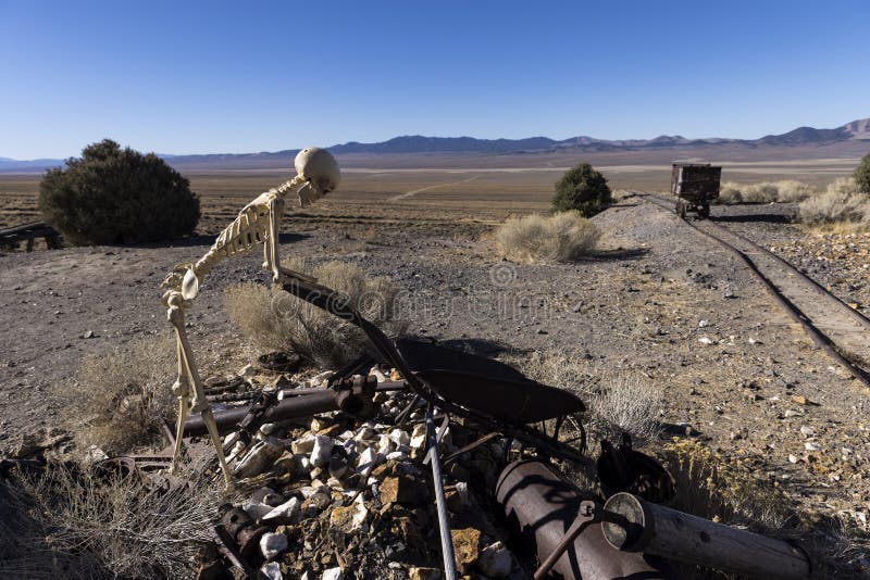 Skeleton Using a Rusty Old Wheelbarrow To Load Trash Near Tracks and an ...