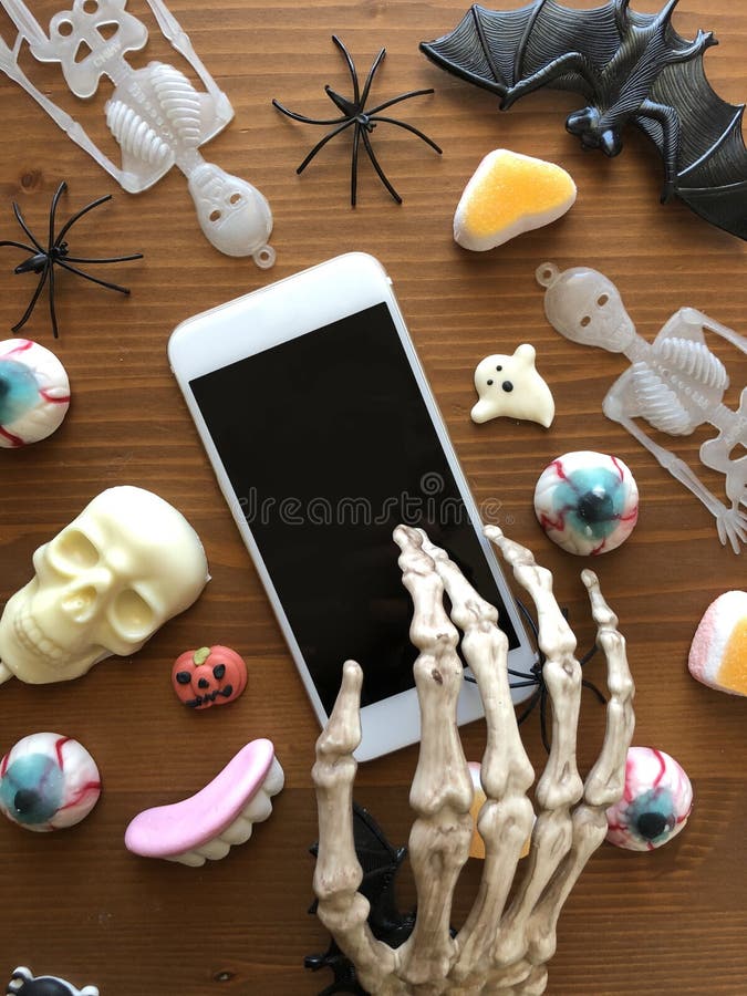 Skeleton Using Smartphone. Halloween Decorations on Wooden Background ...