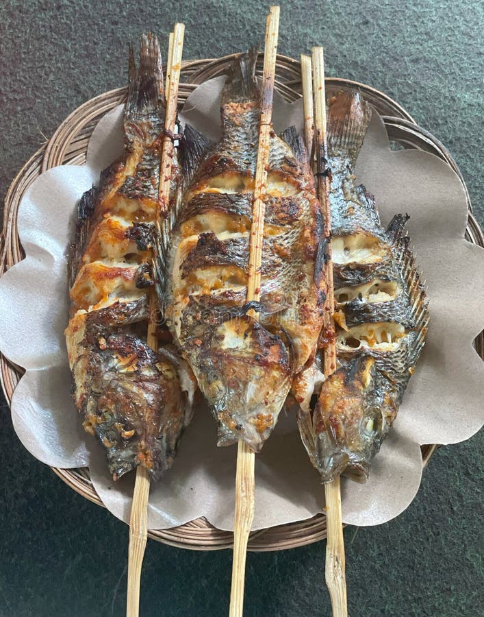 Skewered Fish with Charred Texture on Parchment Paper Stock Image ...